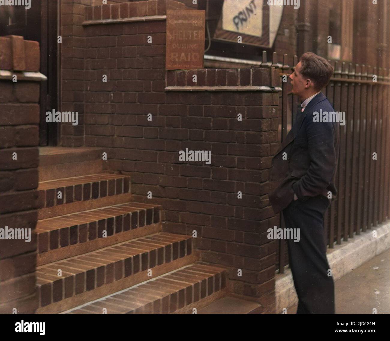 A smart young man reads an air raid notice. Colourised version of ...