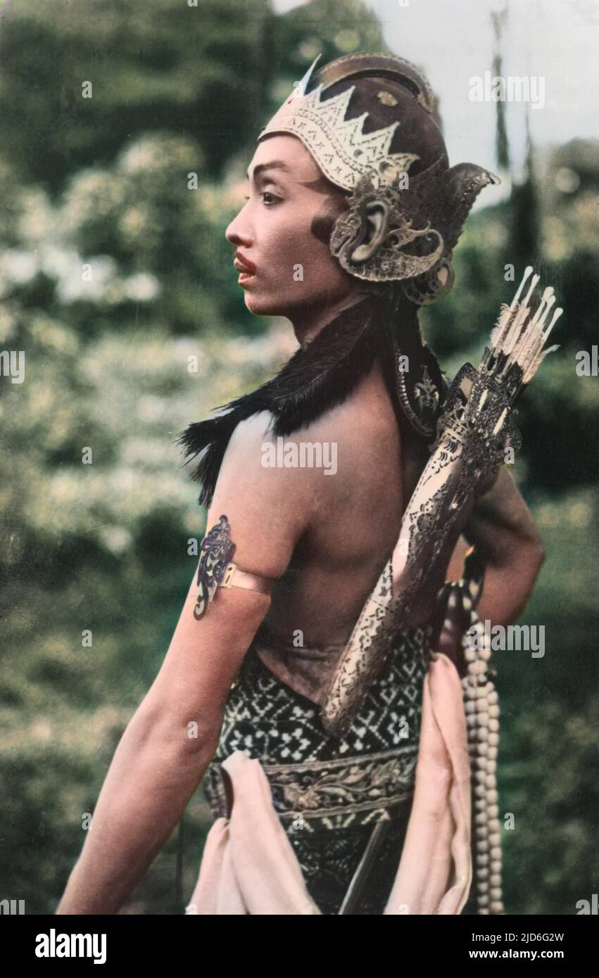 Profile of a native dancer wearing traditional costume, including an elaborate headdress and arm ...