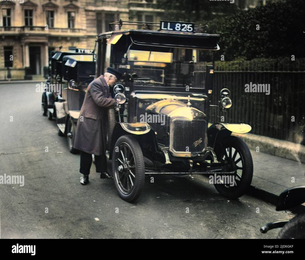 An old taxi cab driver with his 'older' style cab, at the front of a ...