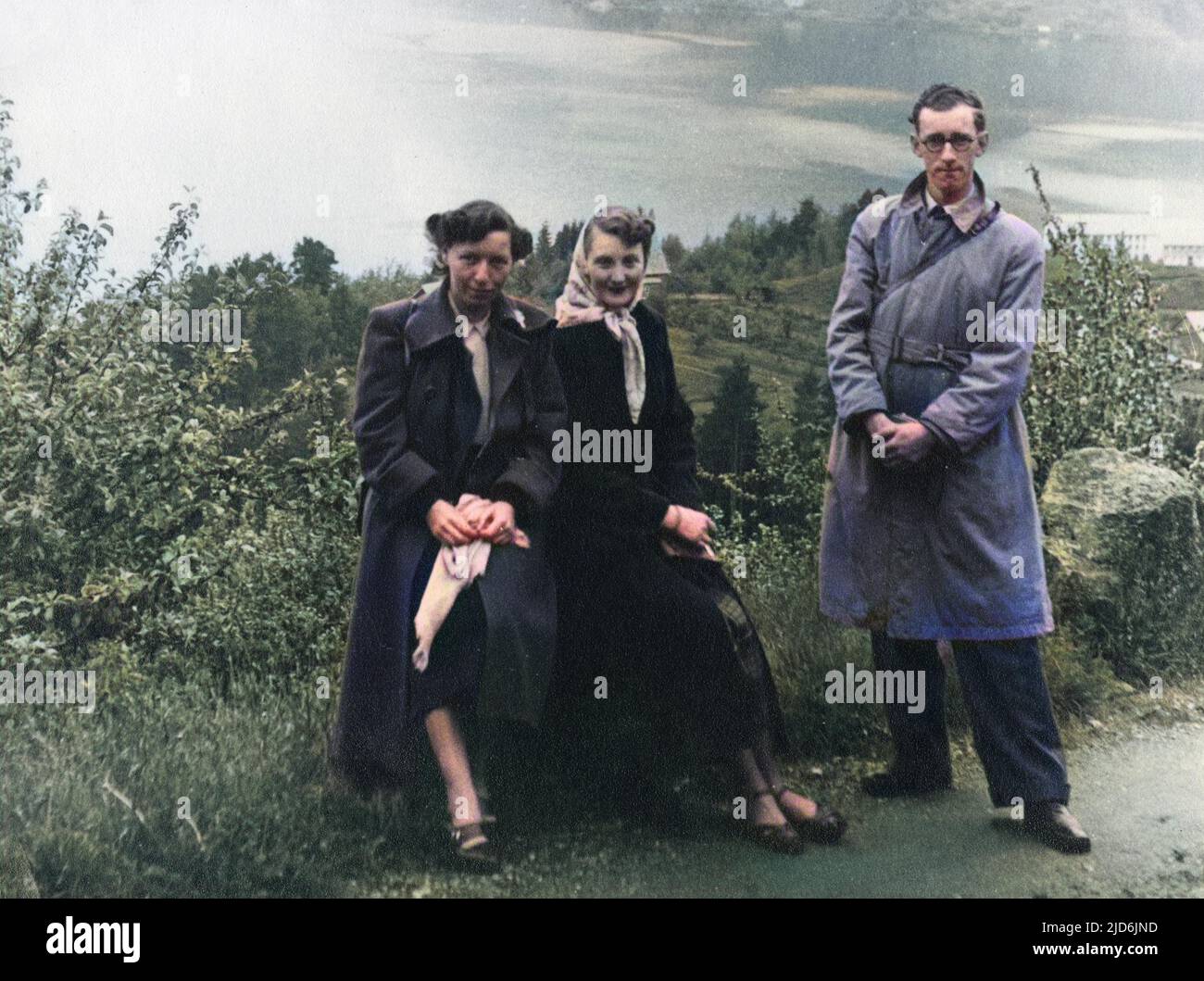 A man and two women on holiday in Norway pose on the hillside ...