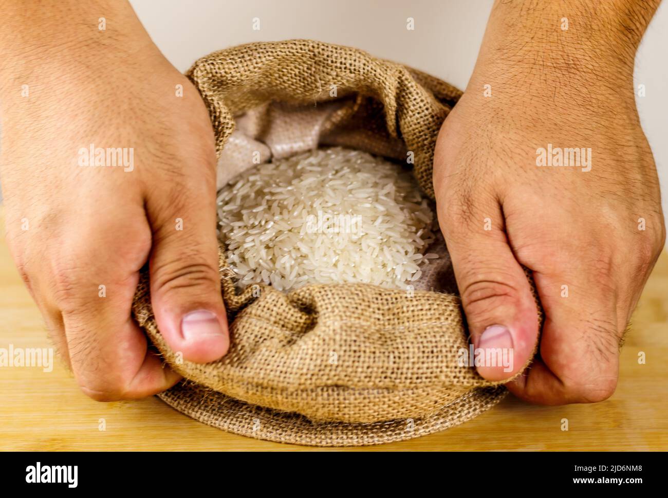 Hands holding rice, bag of rice Stock Photo - Alamy