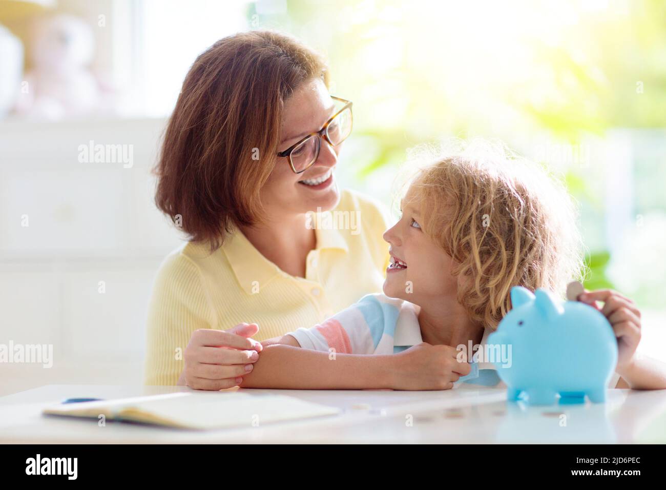 Child putting coin in piggy bank. Kids learn about money. Savings and ...