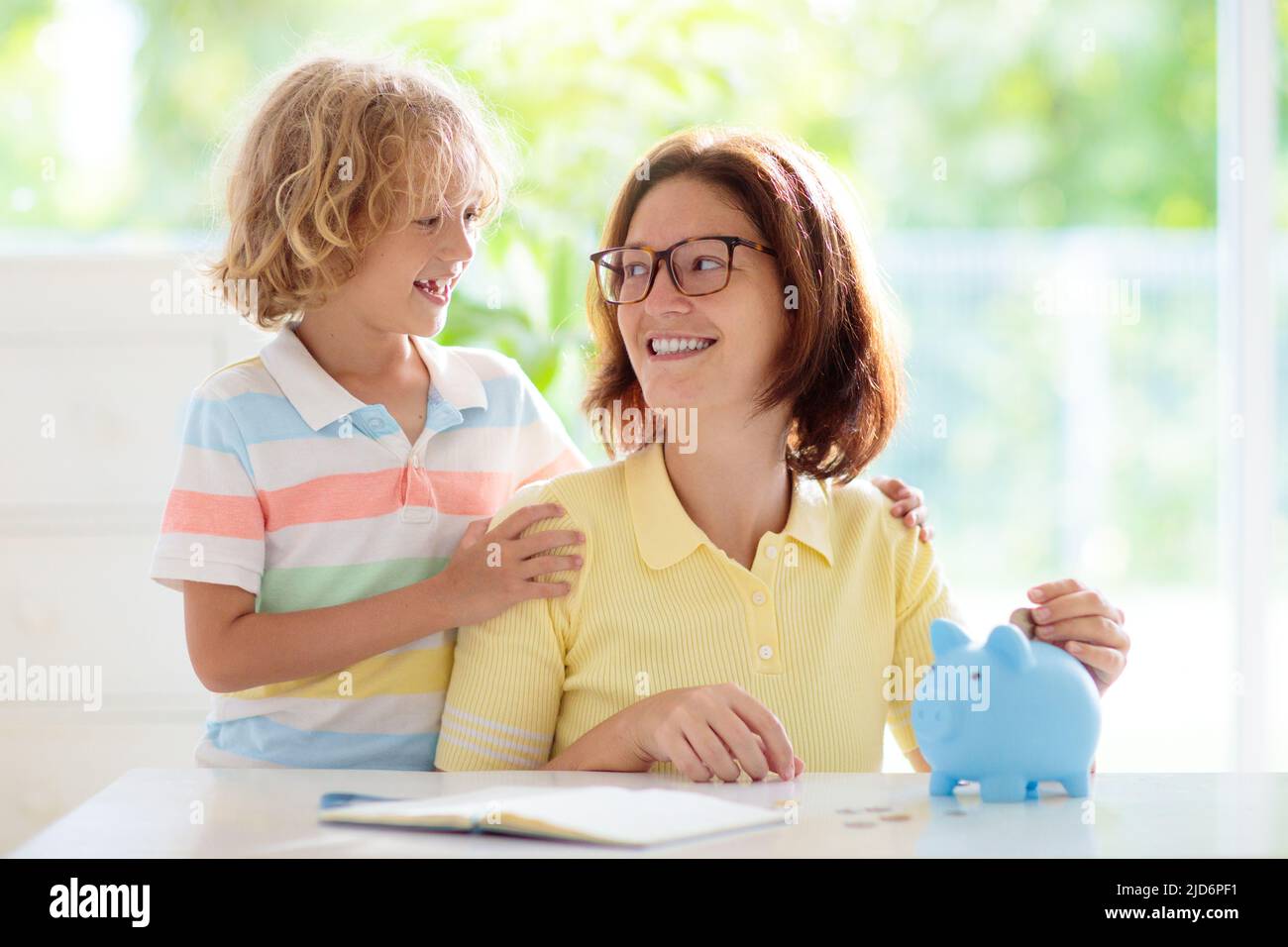 Child putting coin in piggy bank. Kids learn about money. Savings and ...
