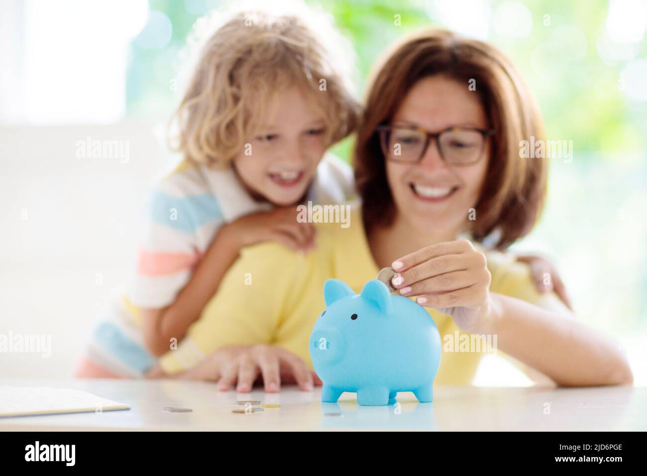 Child putting coin in piggy bank. Kids learn about money. Savings and ...