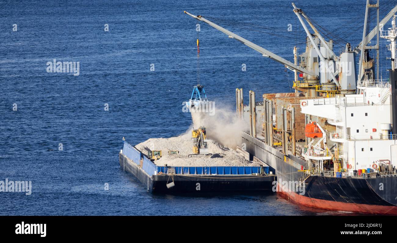 Big Tanker Ship is loading goods onto a barge with a crane Stock Photo ...