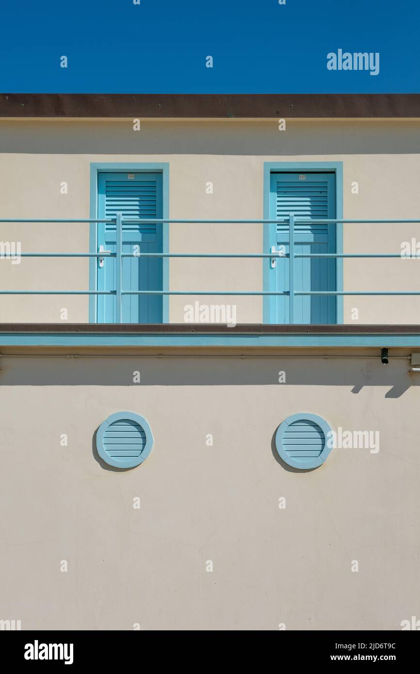 Bright blue doors and round louvered windows in stucco building Stock ...