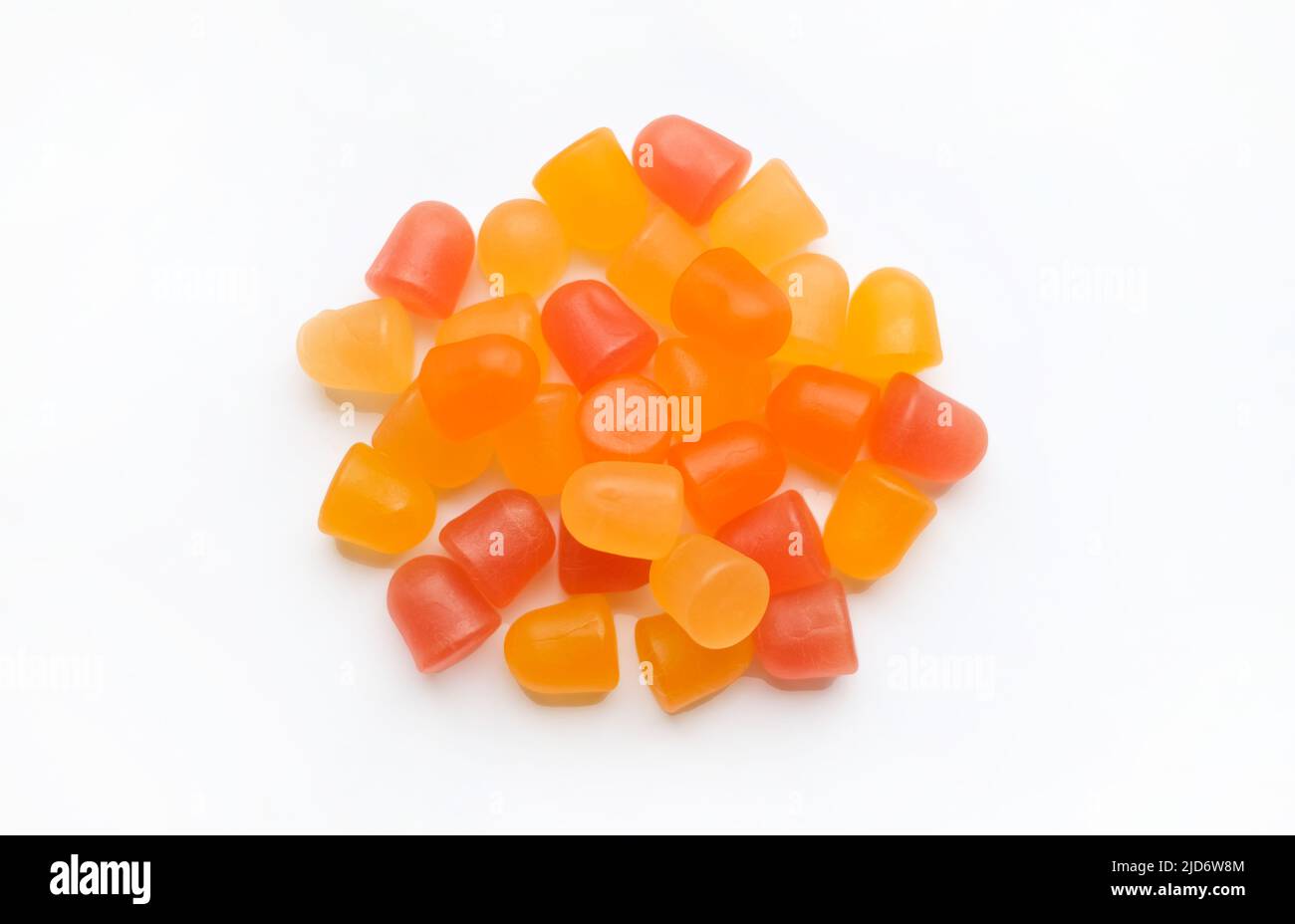 Close-up texture of orange and yellow multivitamin gummies in the form ...