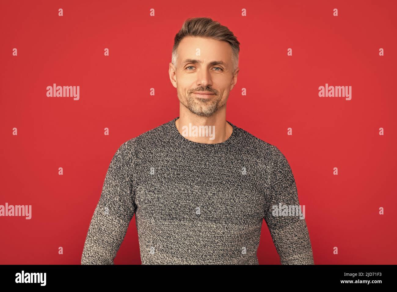 hair and skin care. smiling grizzled guy in sweater on red background ...