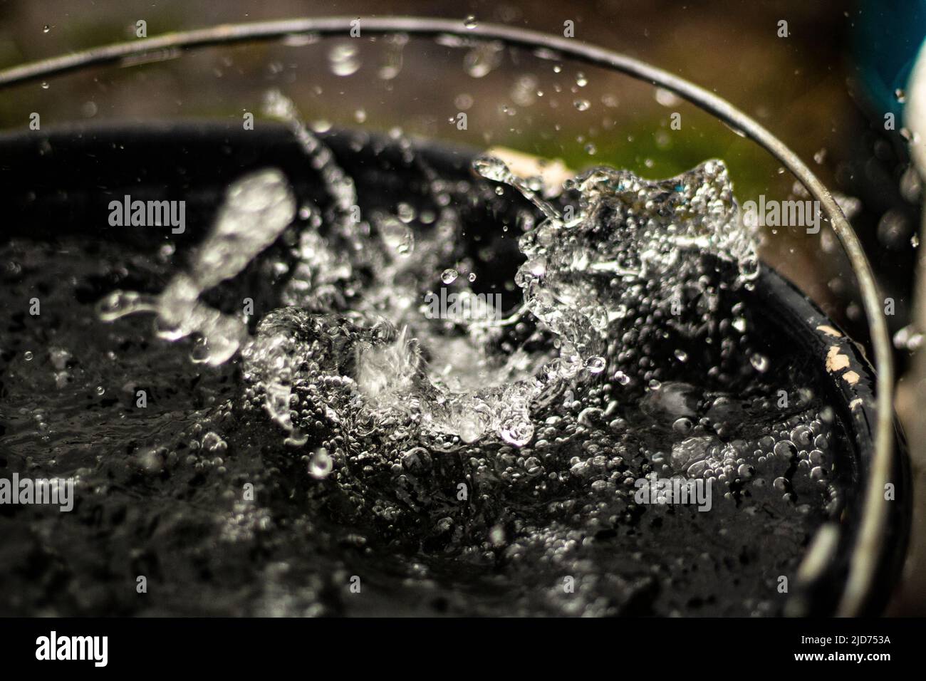 Rain is dripping into bucket. Water splashes in bucket. Details of rain ...