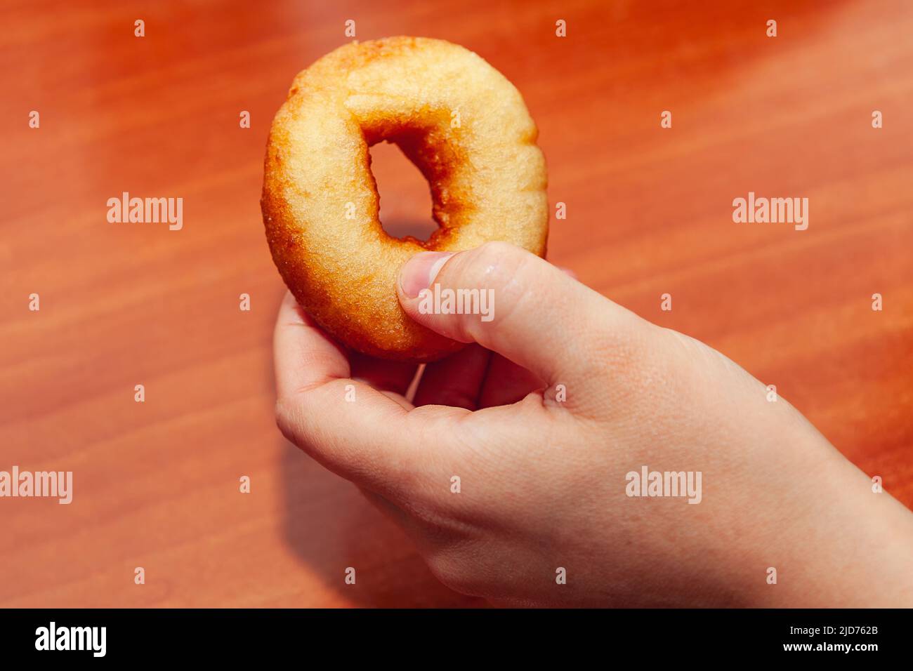 Donut in hand . Sweet and high-calorie dessert Stock Photo - Alamy