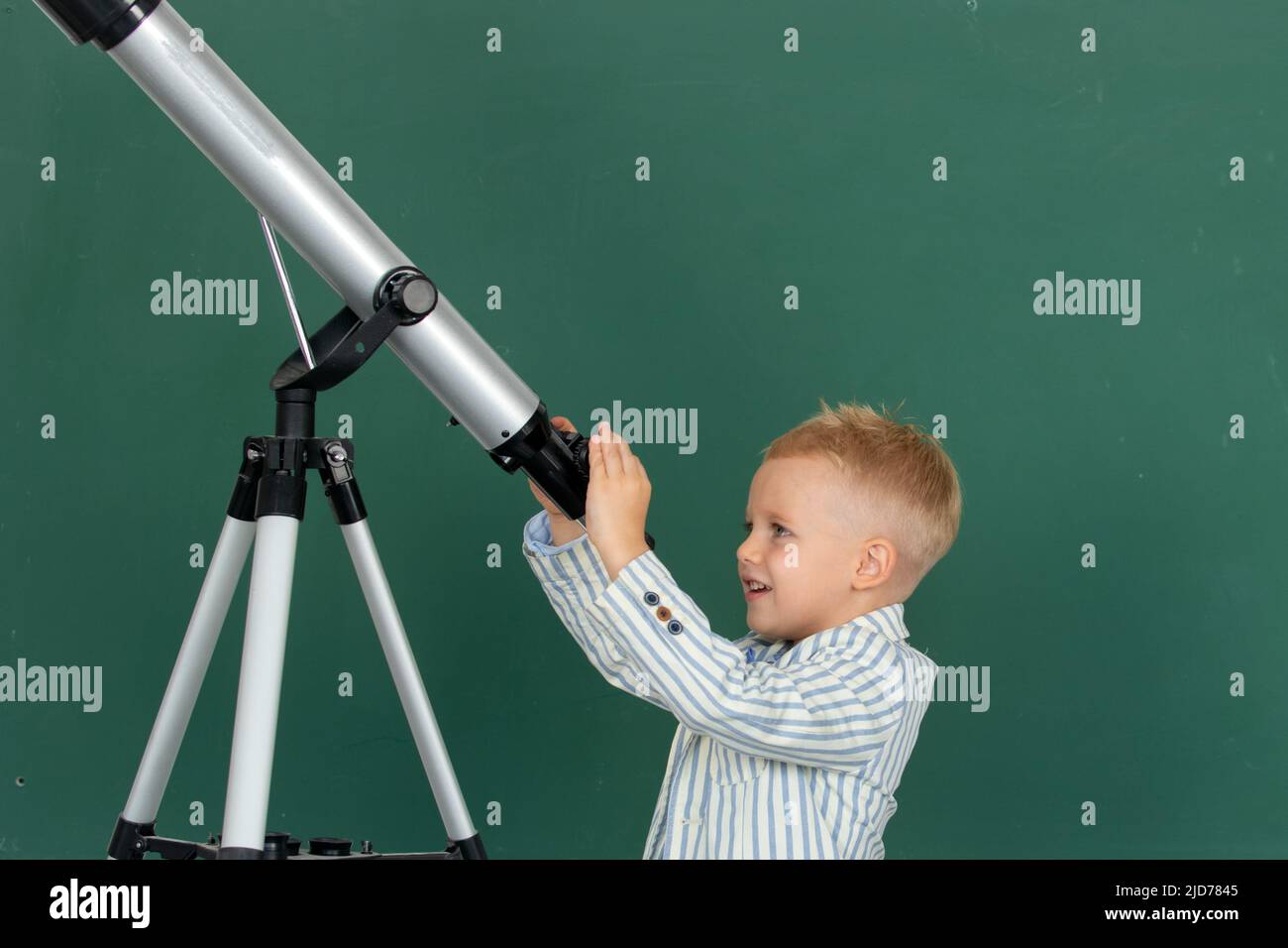 Cute school kid pupil study with telescope in a classroom Stock Photo ...