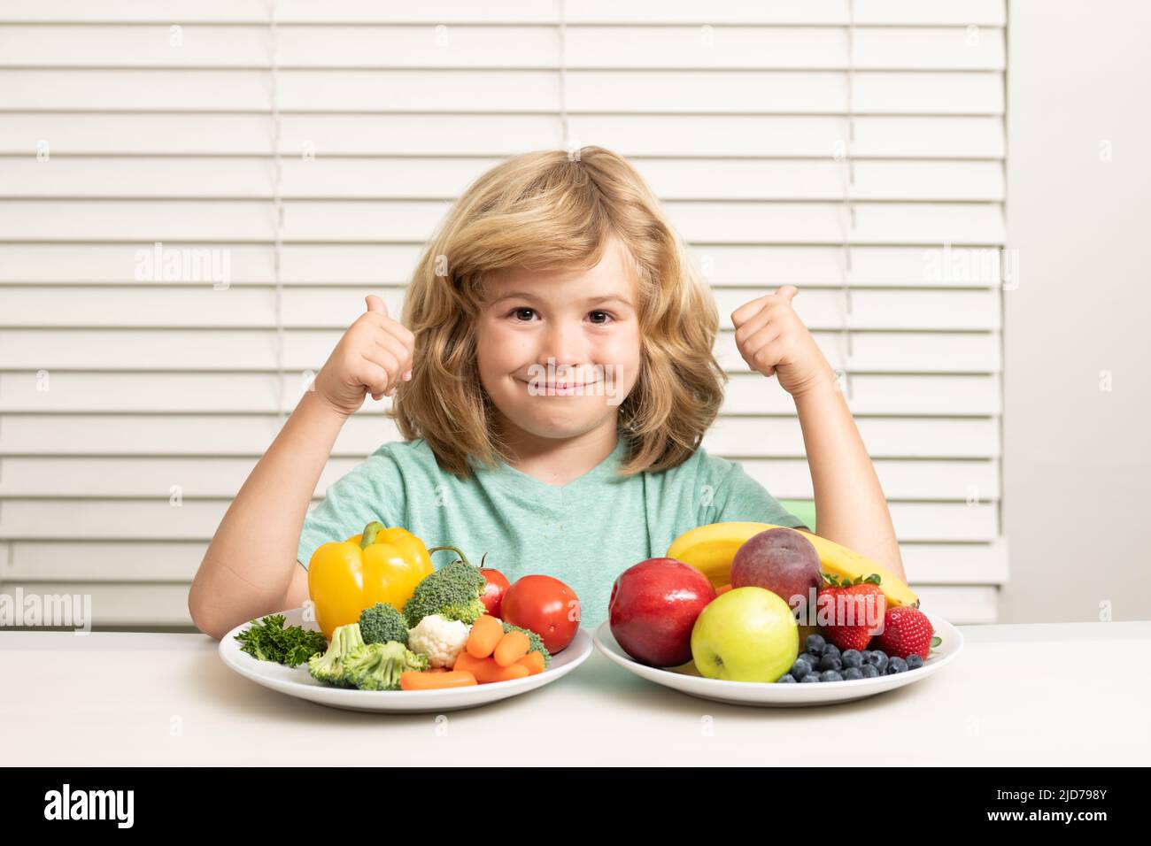 Fruits and vegetables. Funny kid boy having breakfast. Milk, vegetables ...