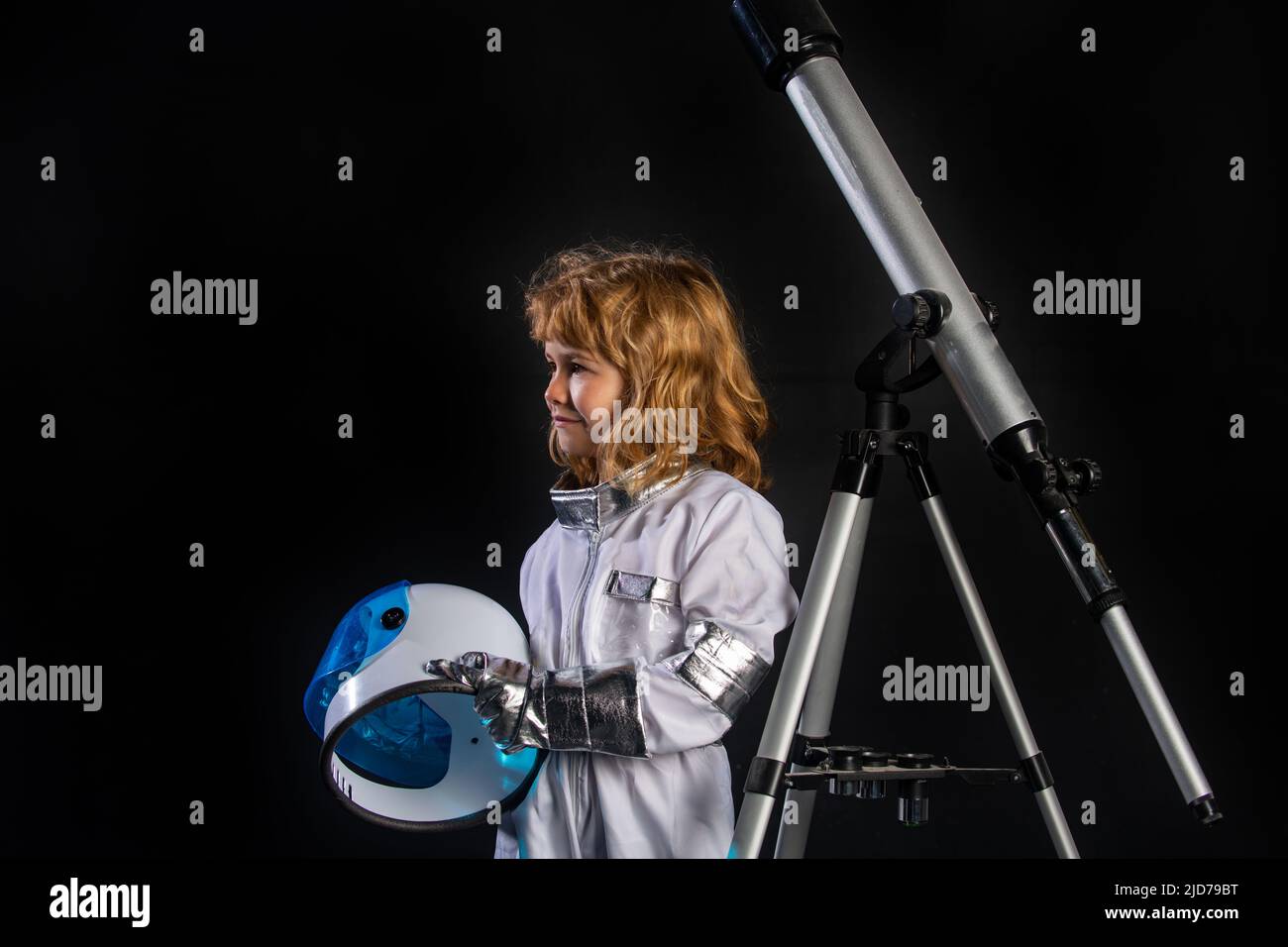 Boy playing to be an astronaut with space helmet, metal suit and ...
