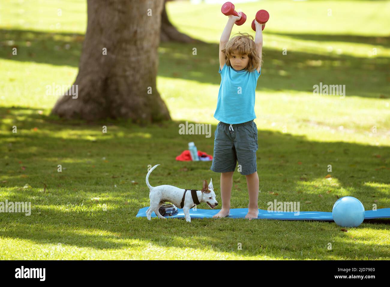 Sport child boy with strong biceps muscles. Kids exercising fitness dumbbells. Strong little boy ...