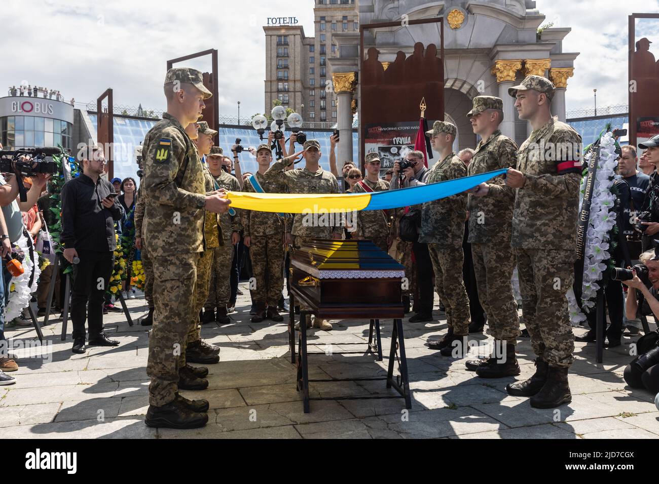 Soldiers cover the Ukrainian flag on the coffin with the body of Roman ...