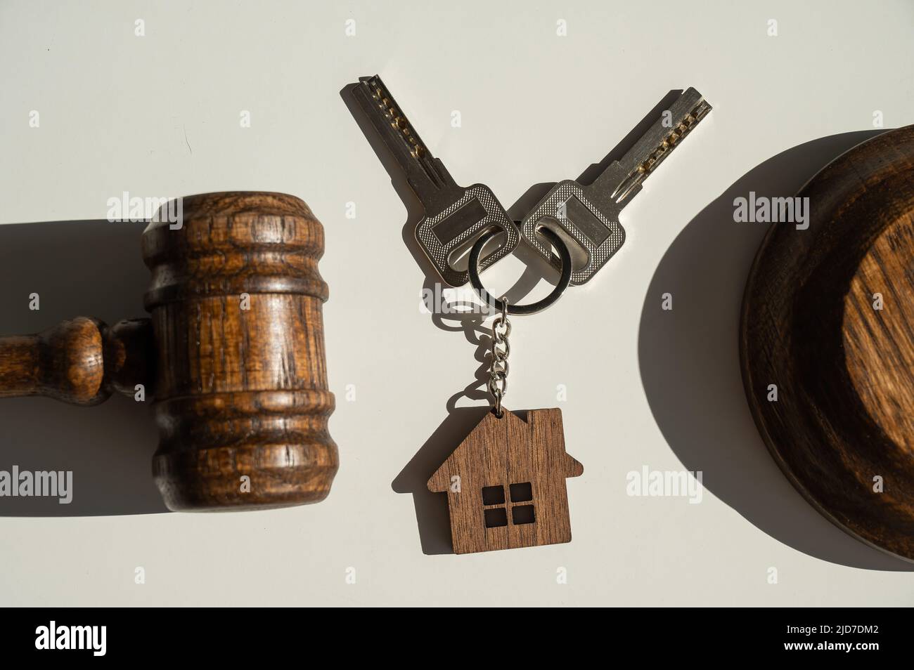 Keys with a keychain in the shape of a house and a judge's gavel on a ...