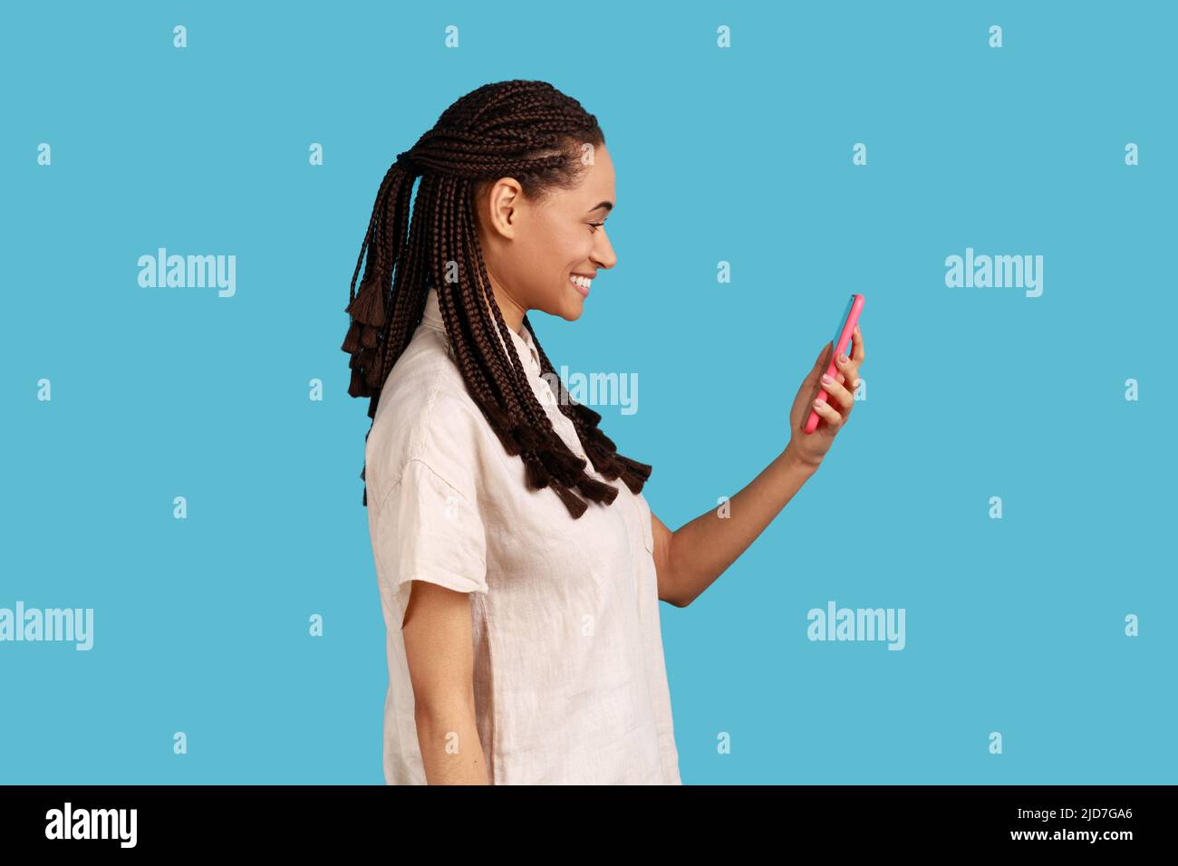 Side view of woman sends text messages via mobile phone, searches gifts ...