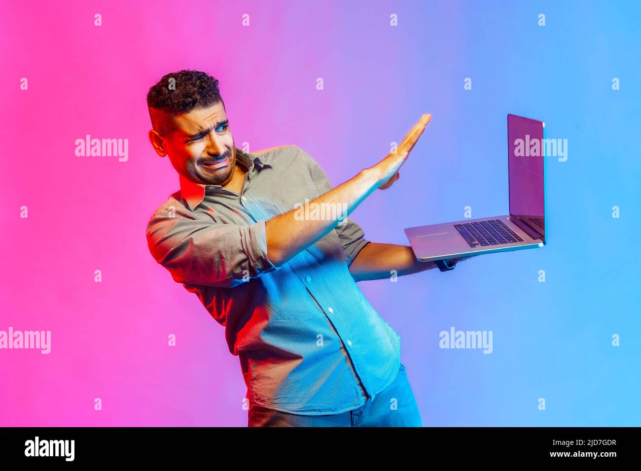 Confused man in shirt showing stop to laptop screen, rejecting ...