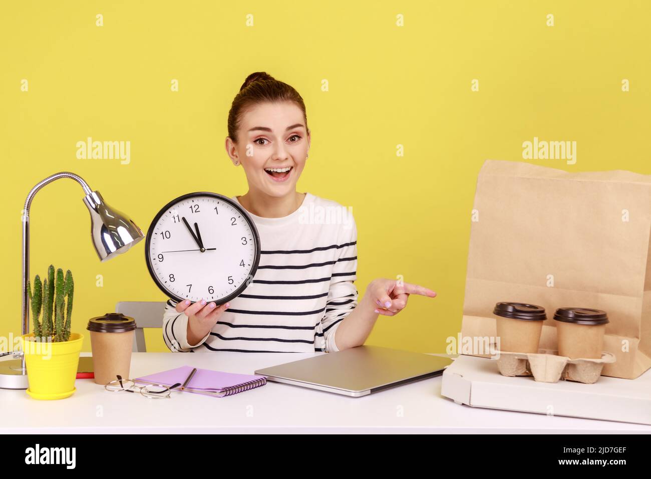 Happy optimistic woman office worker holding big wall clock pointing ...