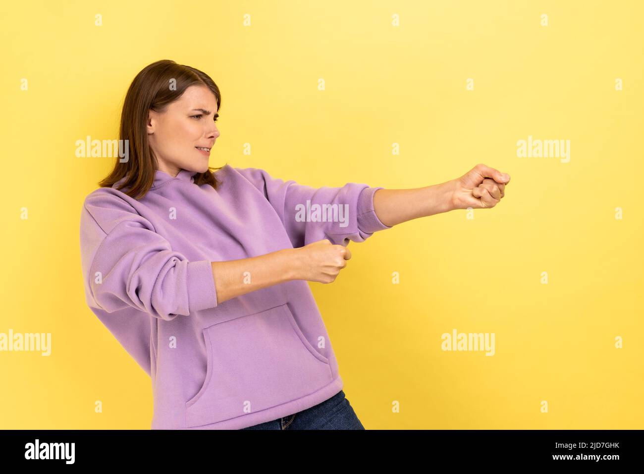 Side view of strong ambitious woman pretending to pull invisible rope ...