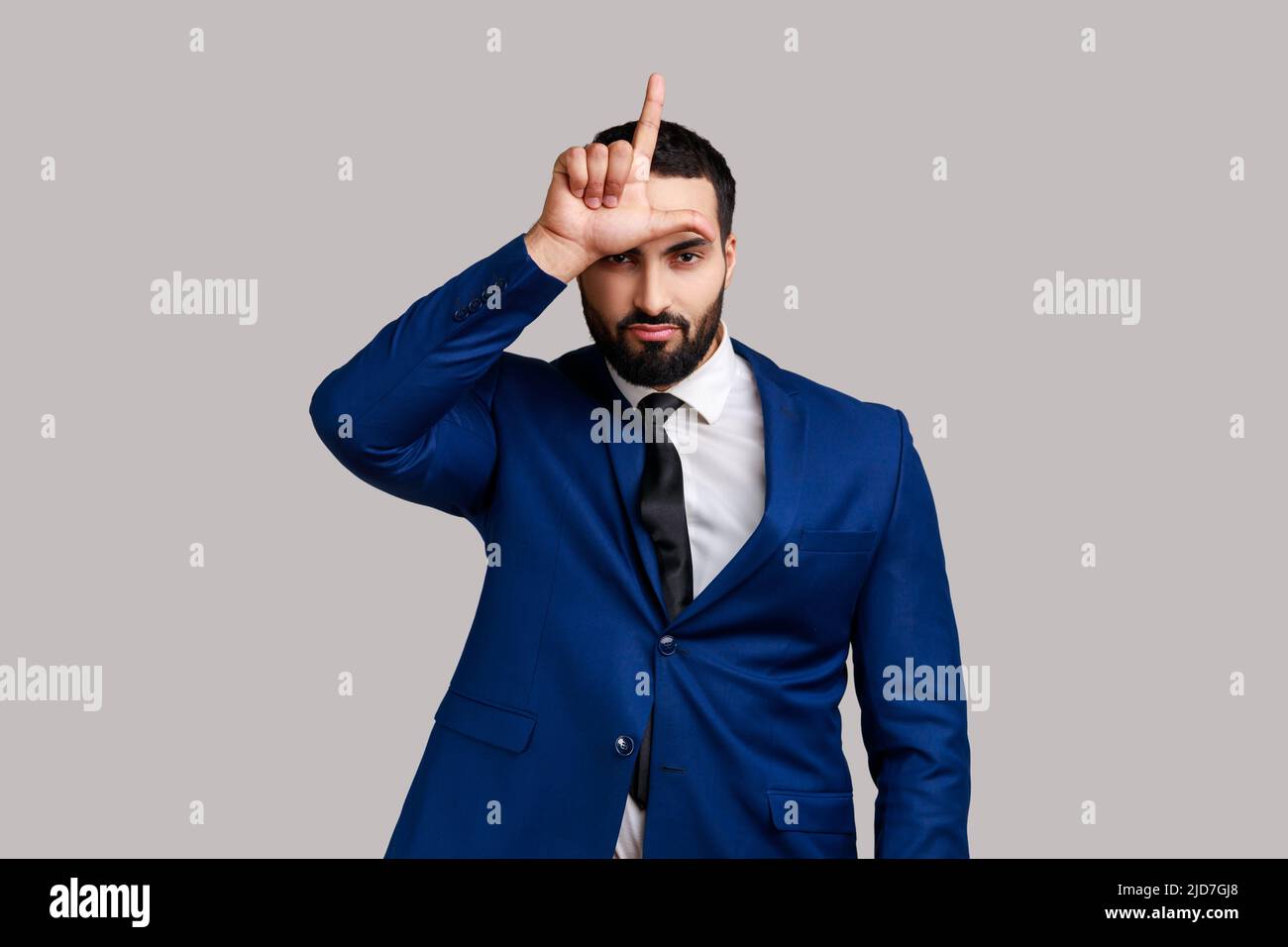 Portrait of upset bearded man showing loser gesture, L finger sign on ...