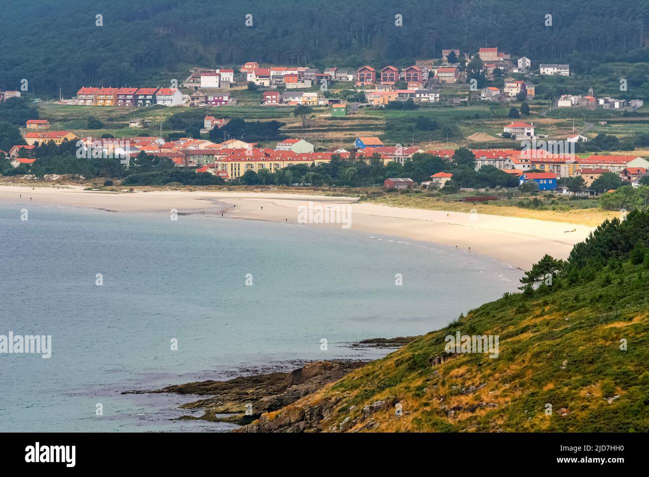 Fine sand beach with colored houses in the north of Spain. Galicia ...