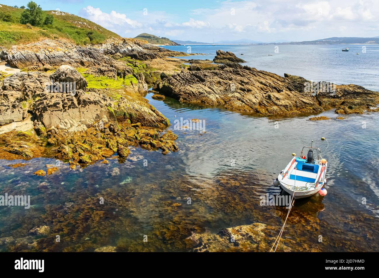 Small motorboat next to the rocks of the sea with transparent waters ...
