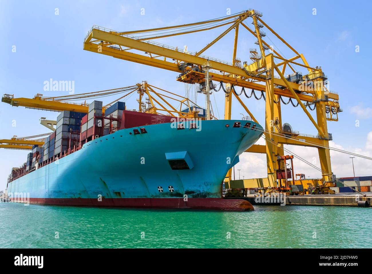 Large container cargo ship next to the cranes in the process of loading ...