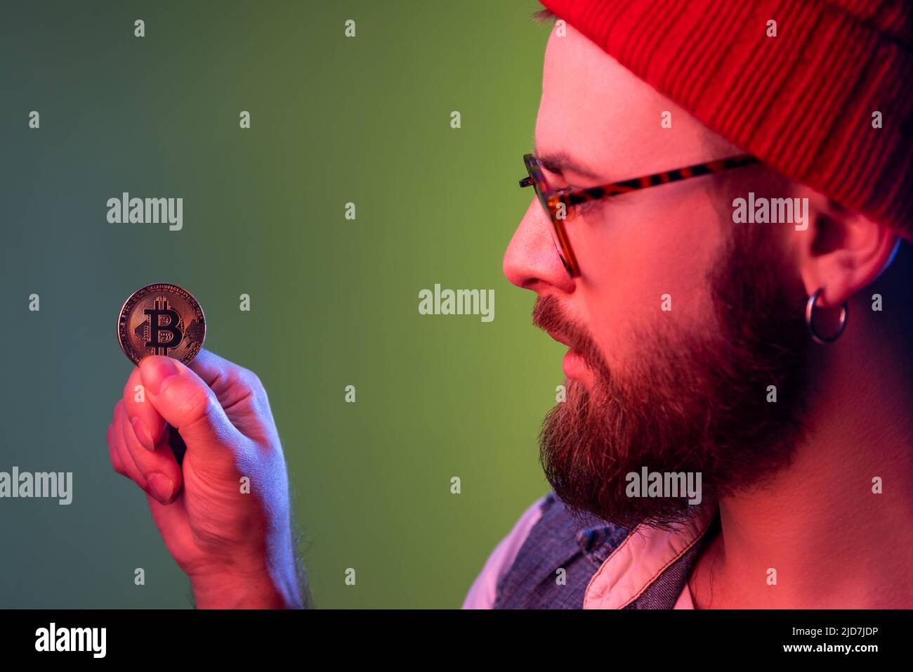 Side view of hipster man with beard standing, holding and looking at ...