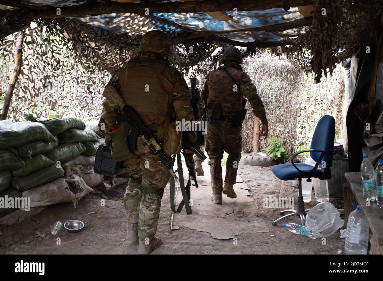 Ukrainian soldiers walk through their front line positions less than ...