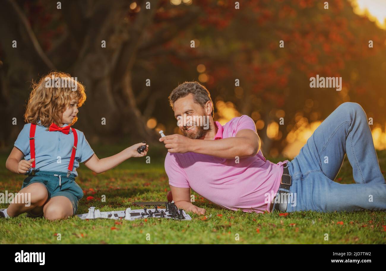 Father and son playing chess spending time together outdoor. Men like ...