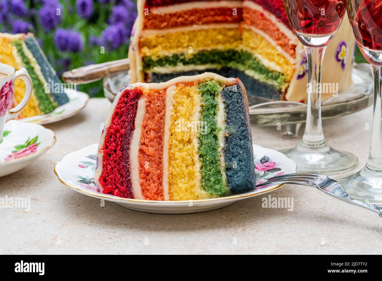 Multi layered rainbow cake set on garden table - outdoor dining Stock ...