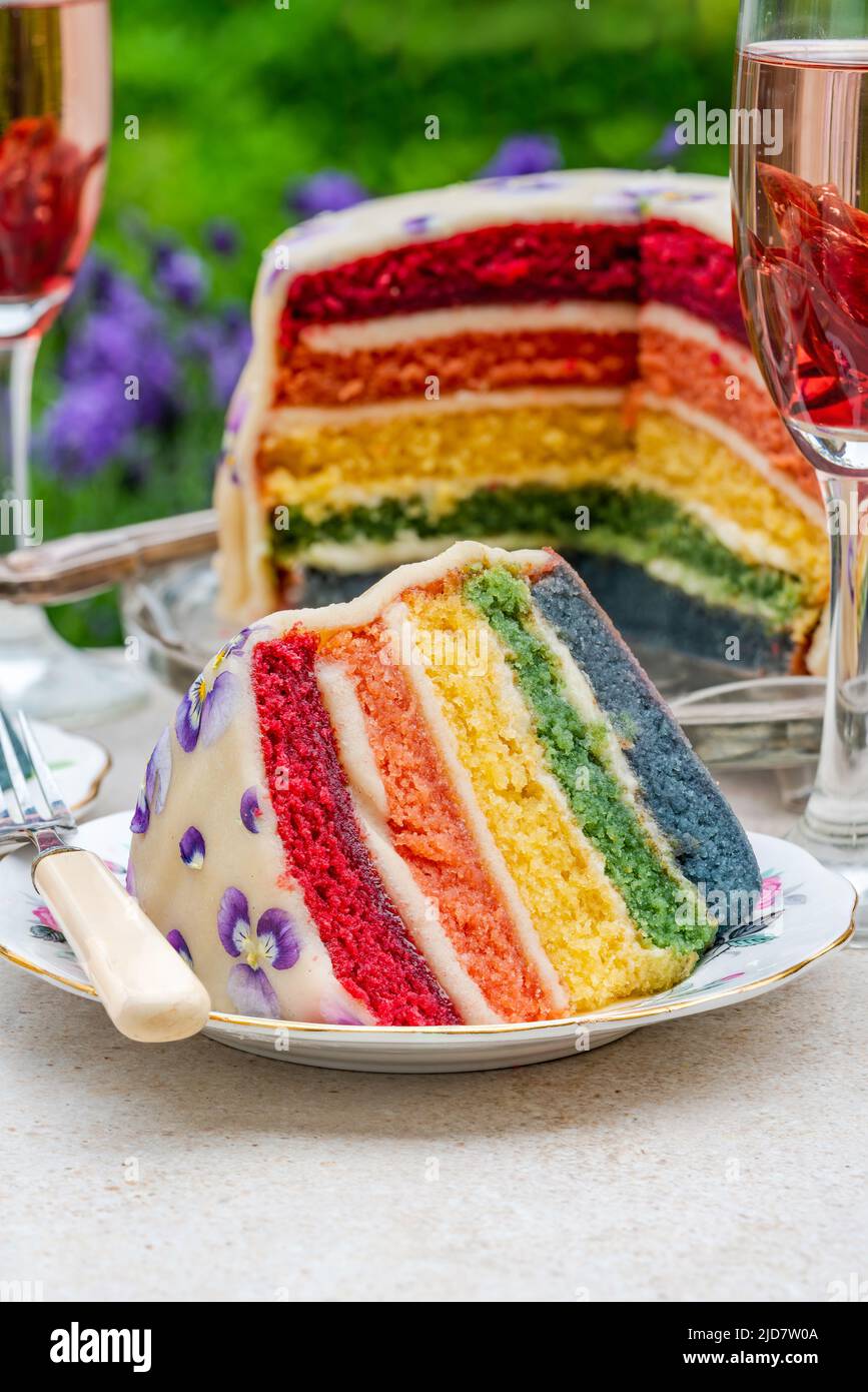 Multi layered rainbow cake set on garden table - outdoor dining Stock ...