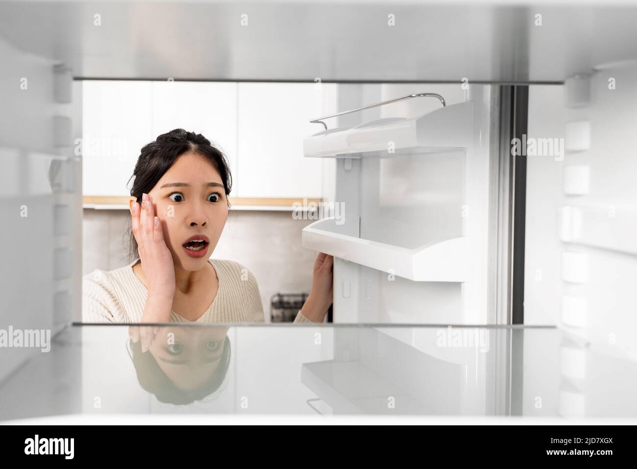 Shocked asian woman looking inside empty fridge Stock Photo - Alamy