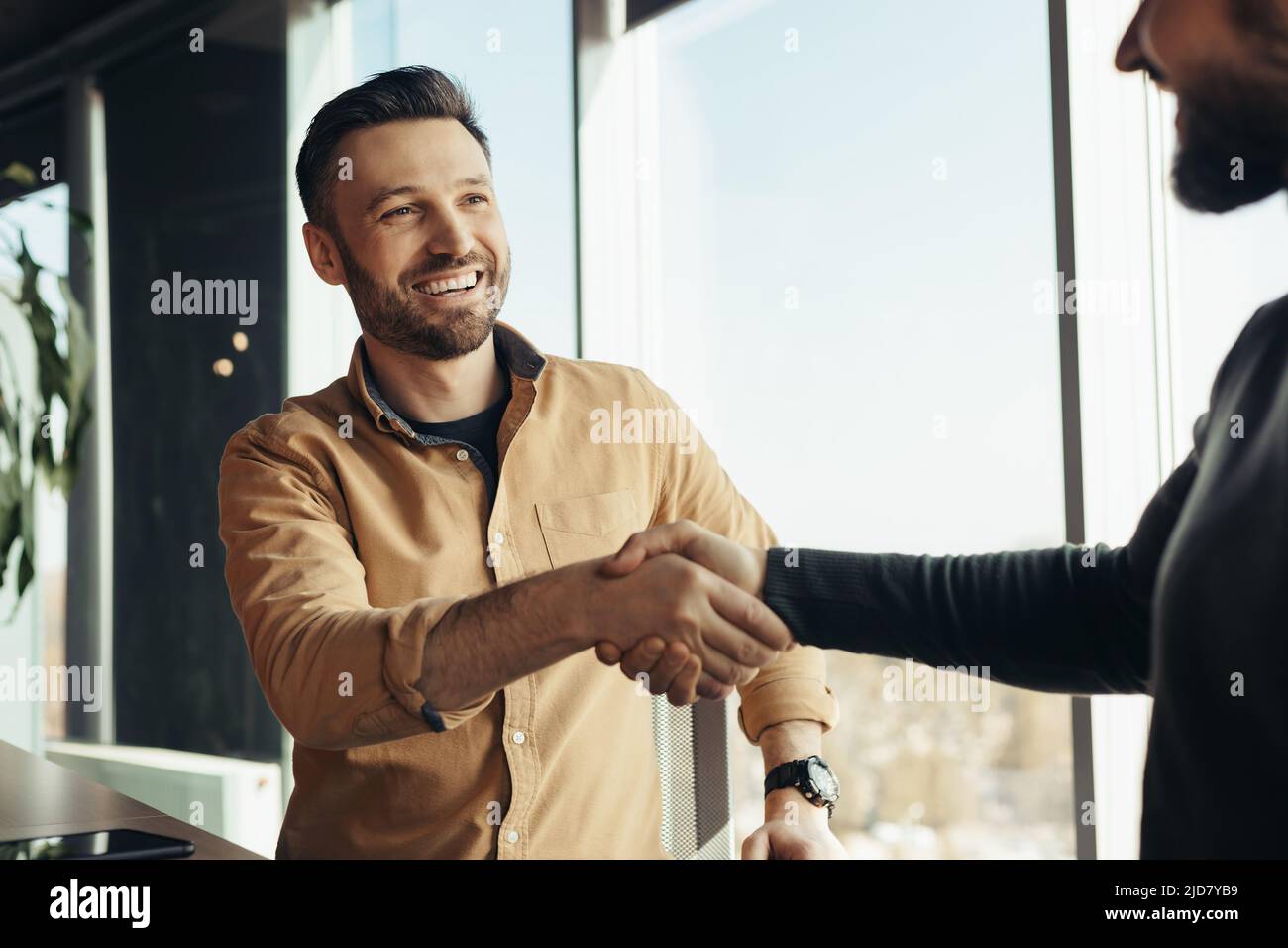 Business partnership. Smiling male entrepreneurs shaking hands ...