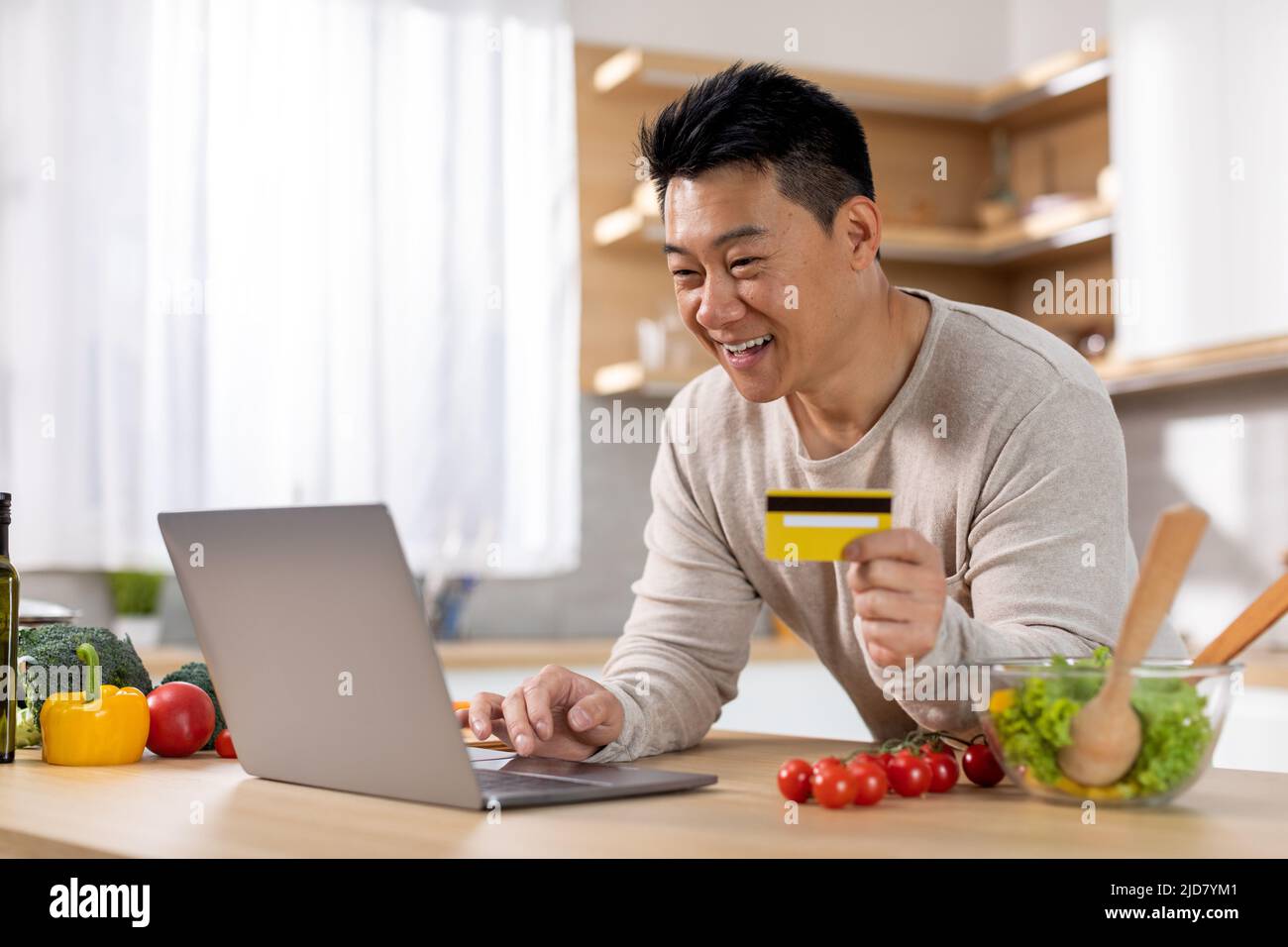 Positive chinese man buying food online, cooking at home Stock Photo ...