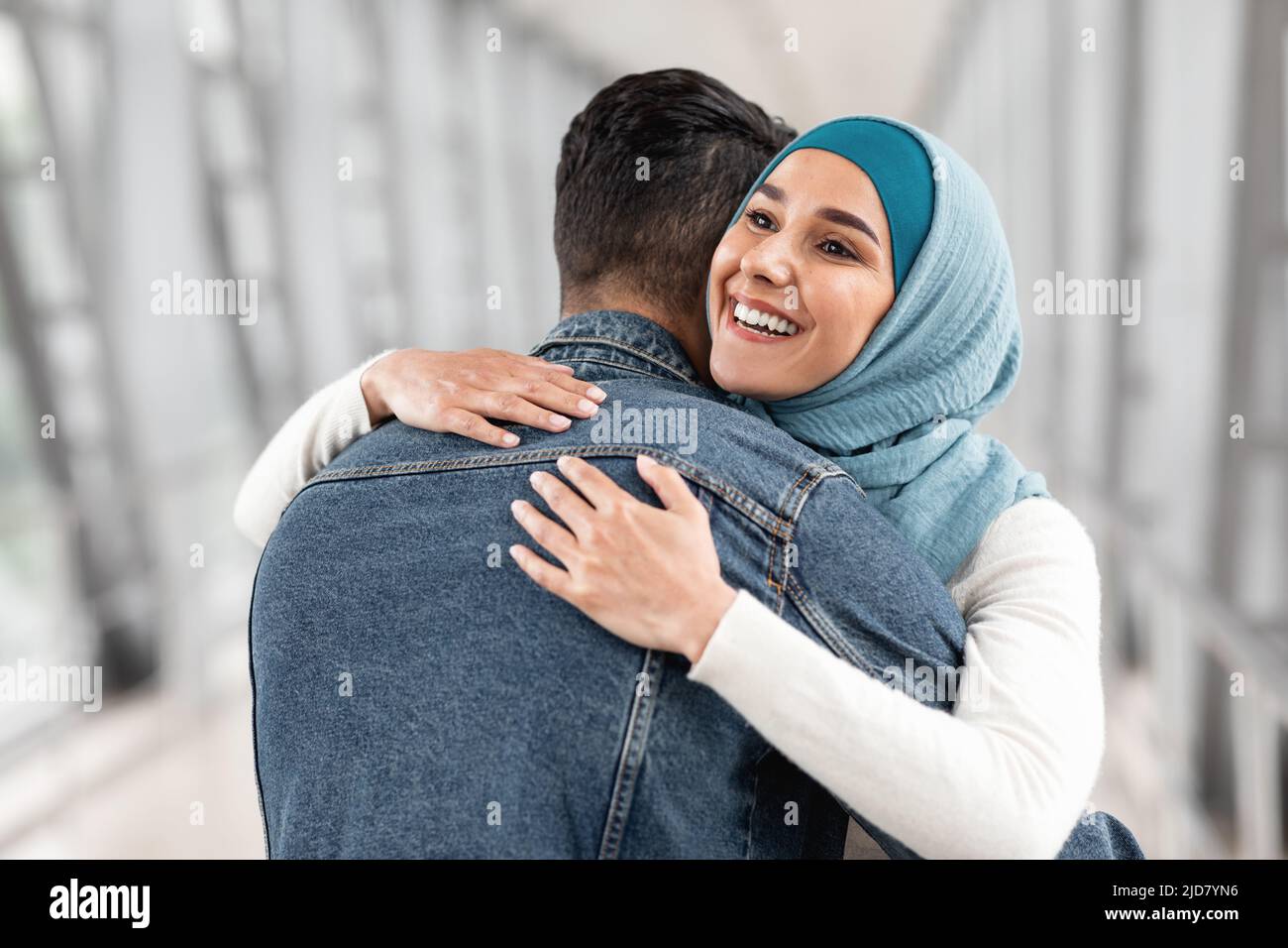 Happy Reunion. Joyful Muslim Woman In Hijab Hugging Her Husband At ...