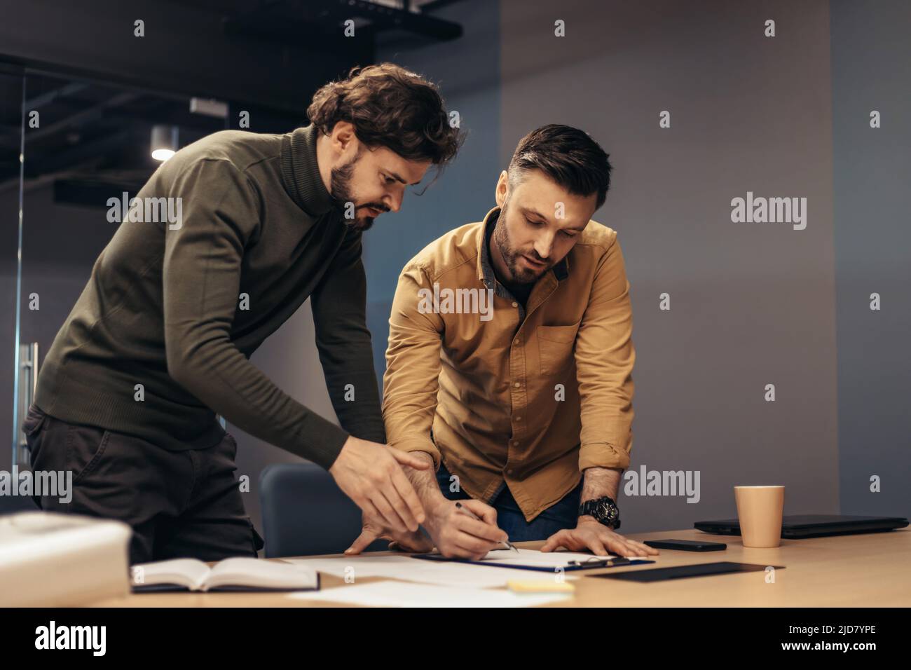 Male colleagues working on startup project, taking notes during ...