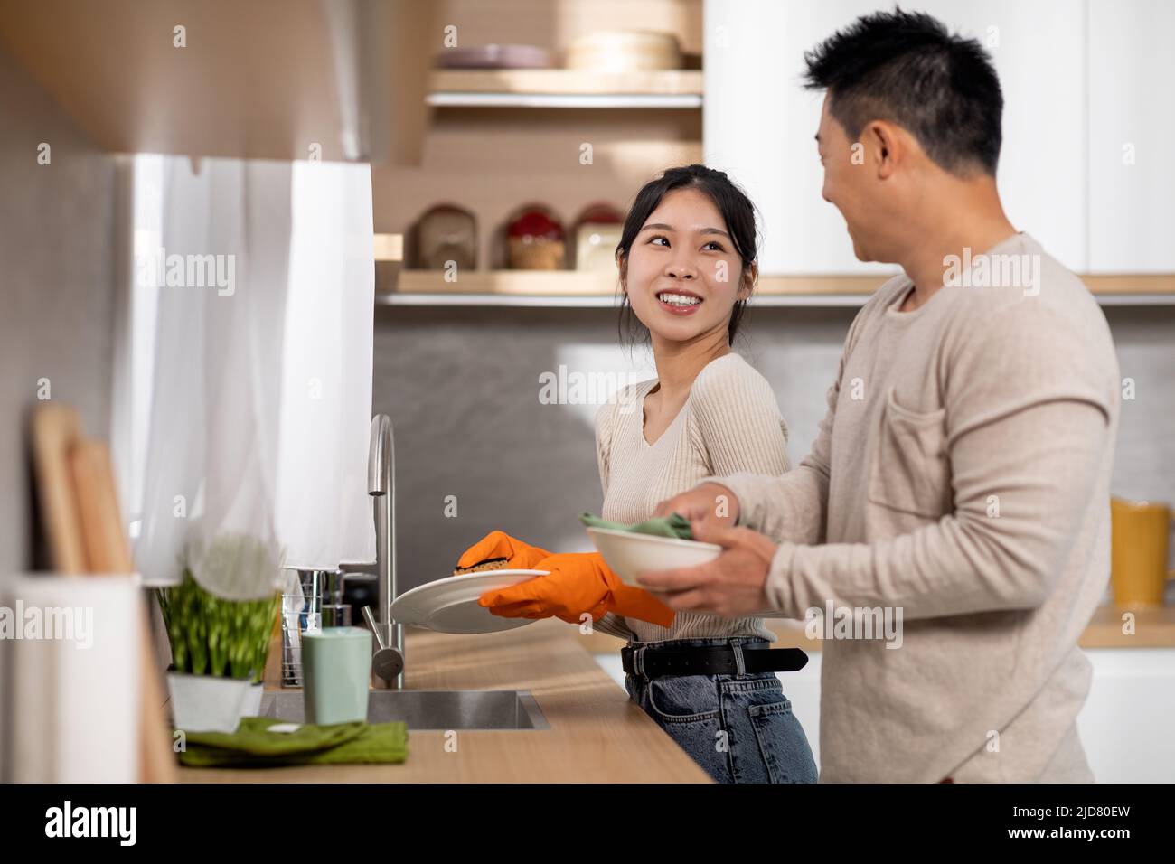 Happy asian couple washing dishes together at home Stock Photo - Alamy