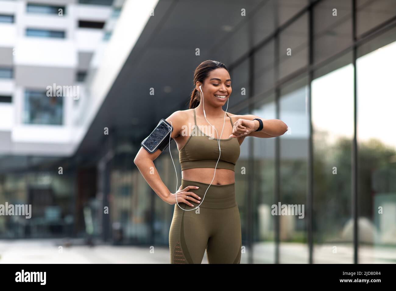Young black woman looking at smartwatch, tracking fitness activity ...