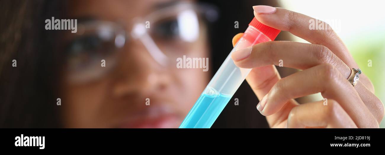 Dark-skinned female laboratory assistant holding a test tube Stock ...