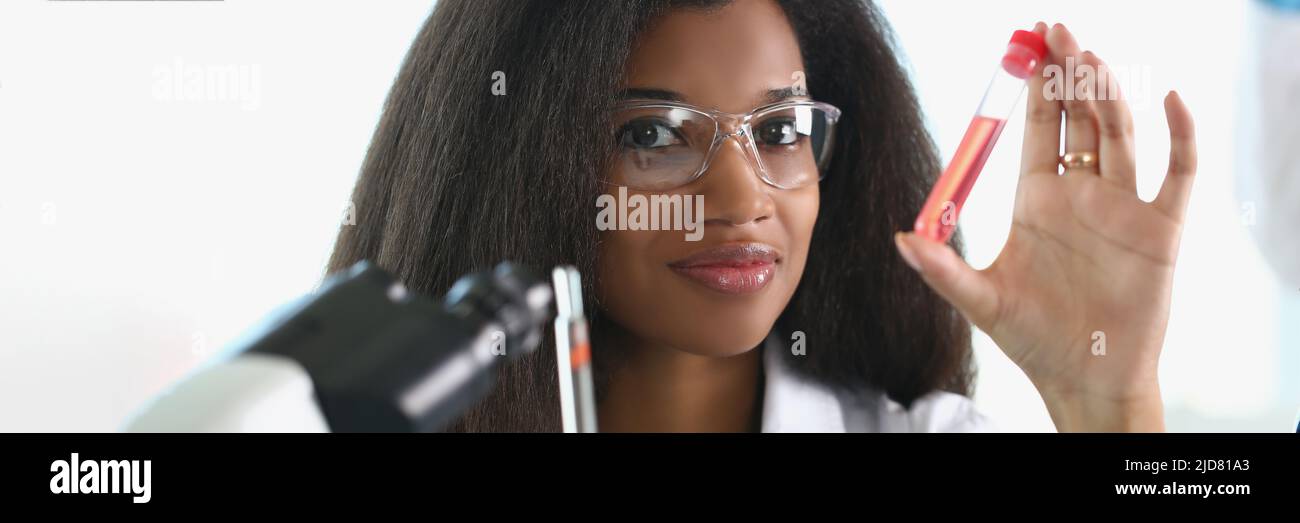 A dark-skinned female laboratory assistant holds a sample Stock Photo ...