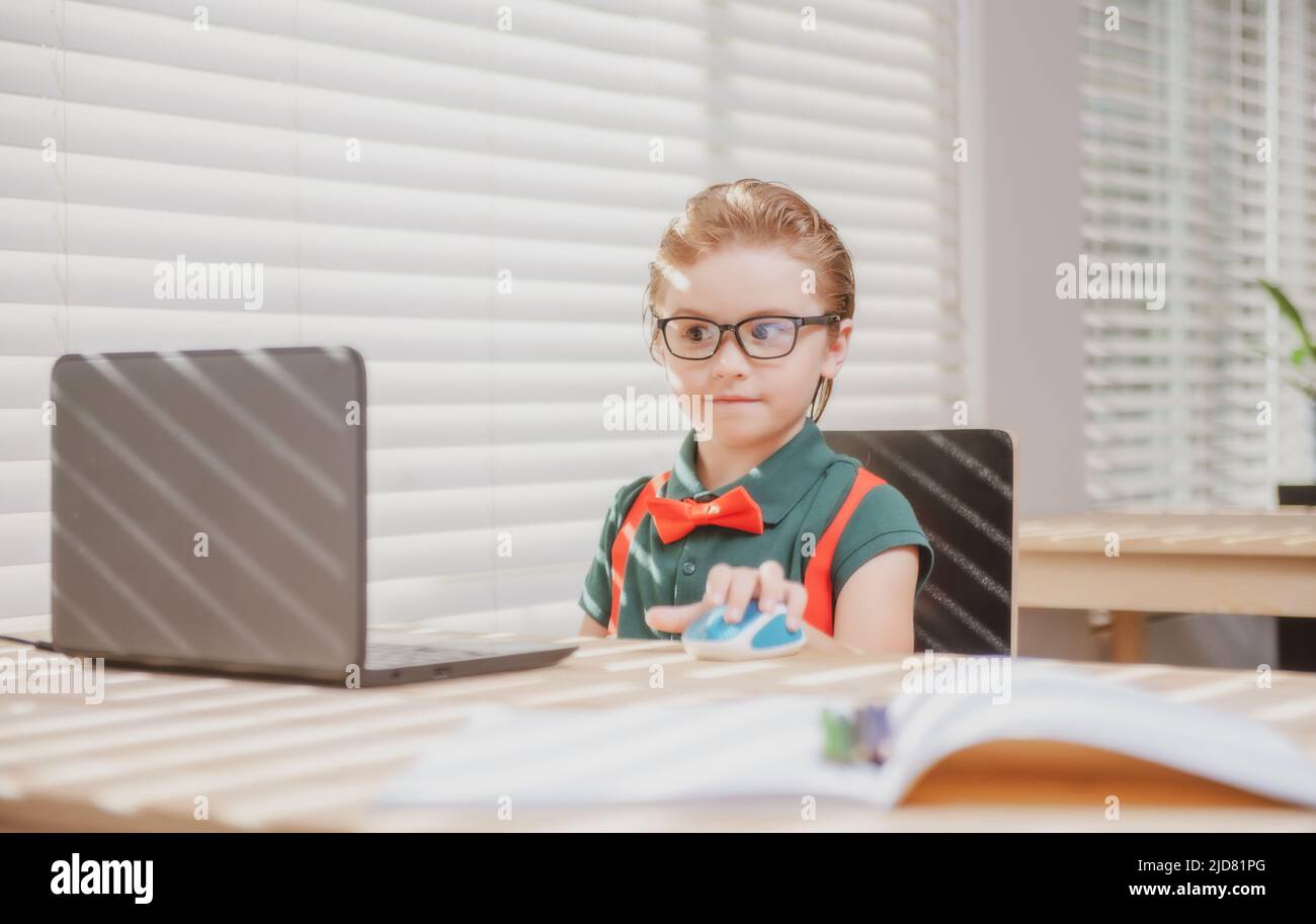 First day at school. Cute little child using laptop computer, studying ...