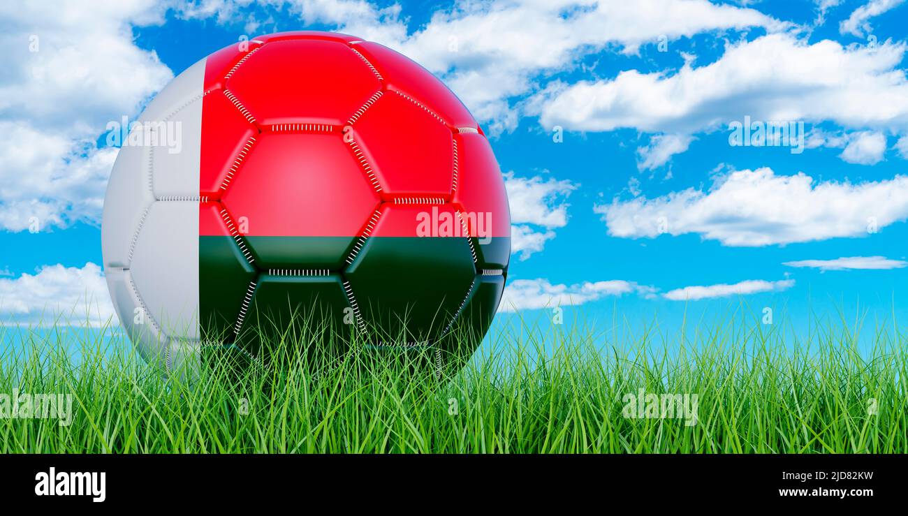 Soccer ball with Madagascar flag on the green grass against blue sky ...