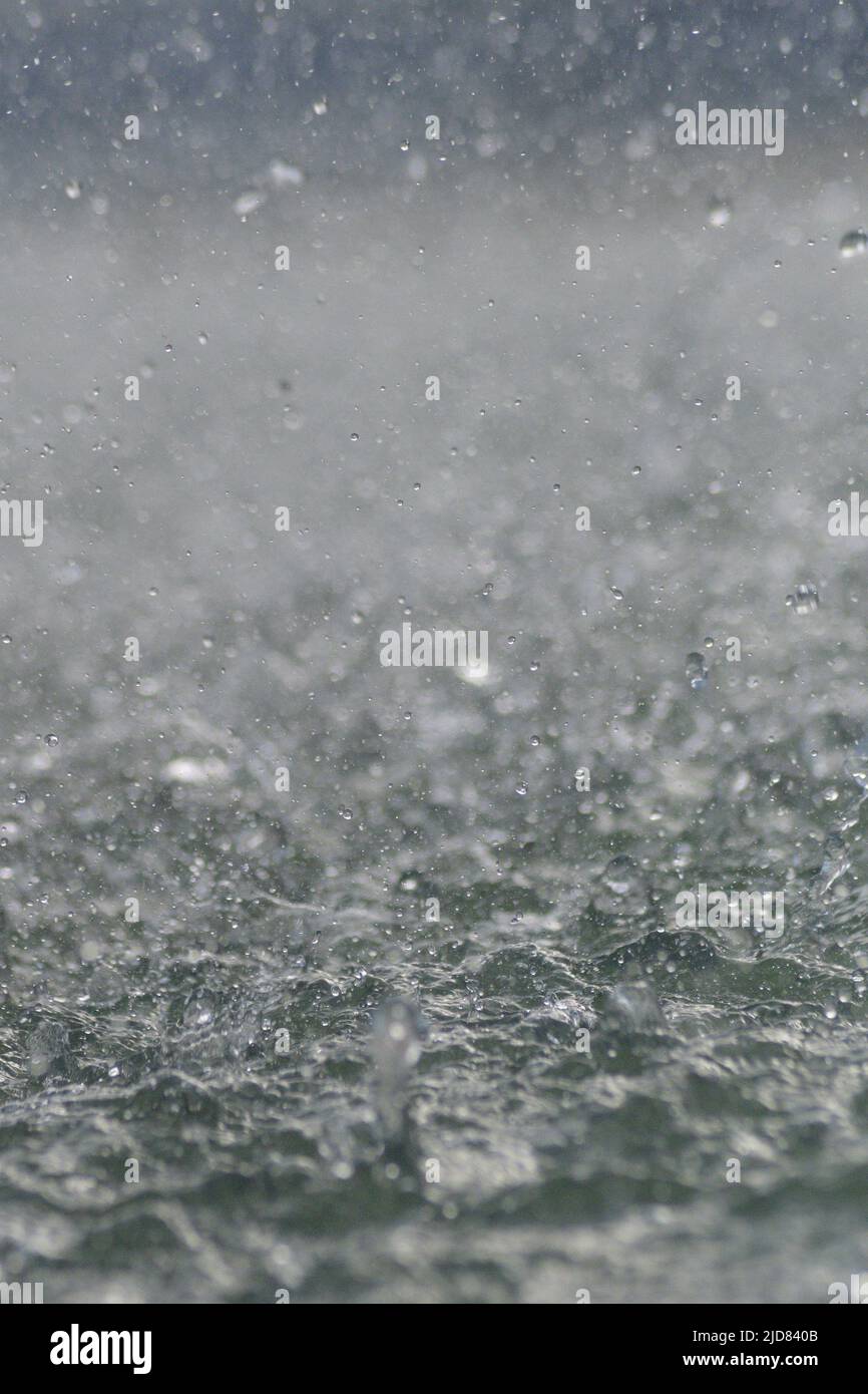 Water drops falling in a puddle Stock Photo - Alamy