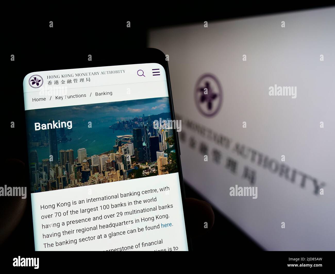 Person holding cellphone with webpage of Hong Kong Monetary Authority ...
