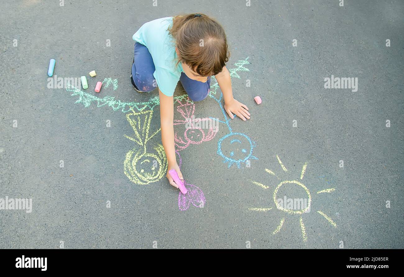 Child draws a family on the pavement with chalk. Selective focus Stock ...