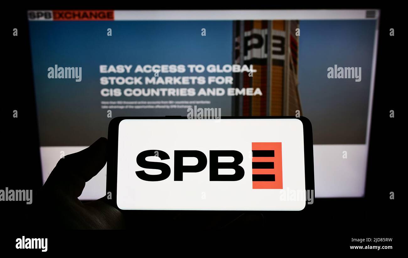 Person holding smartphone with logo of Russian financial marketplace ...