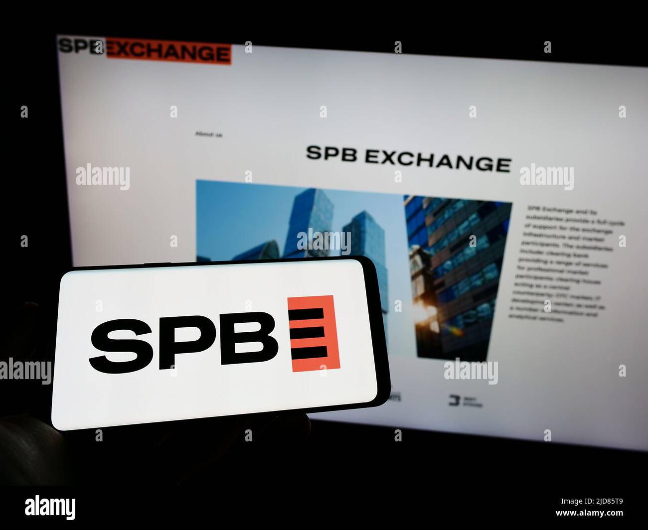 Person holding mobile phone with logo of Russian financial marketplace ...