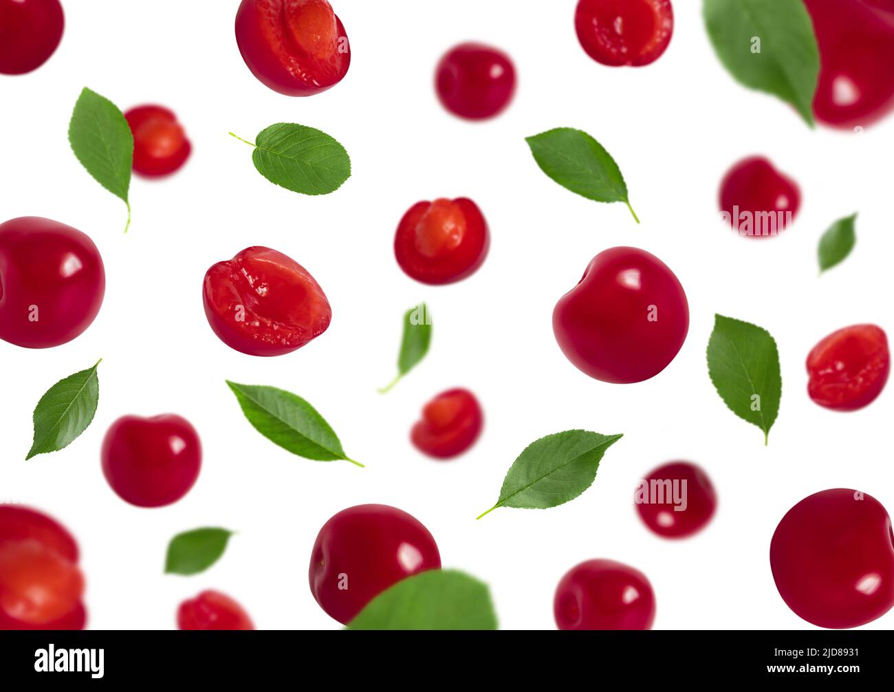 Set of falling cherries with green leaves isolated on a white ...